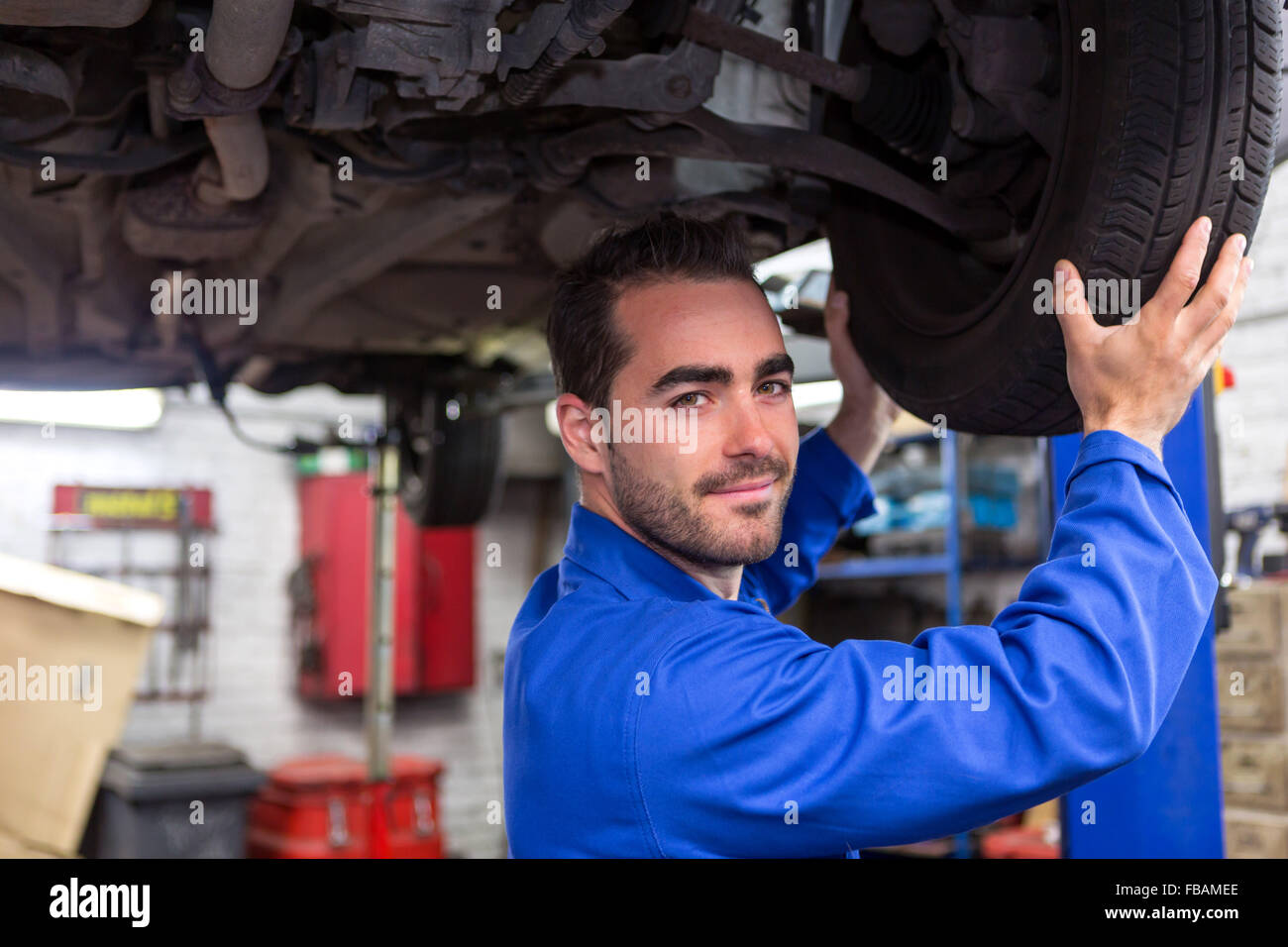 View of a Young attractive mechanic working on a car at the garage Stock Photo - Alamy