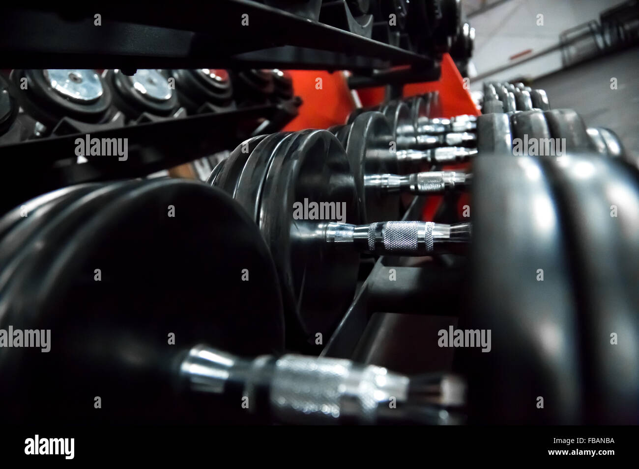 Weight training equipment, row of steel sports dumbbells in sports club ...