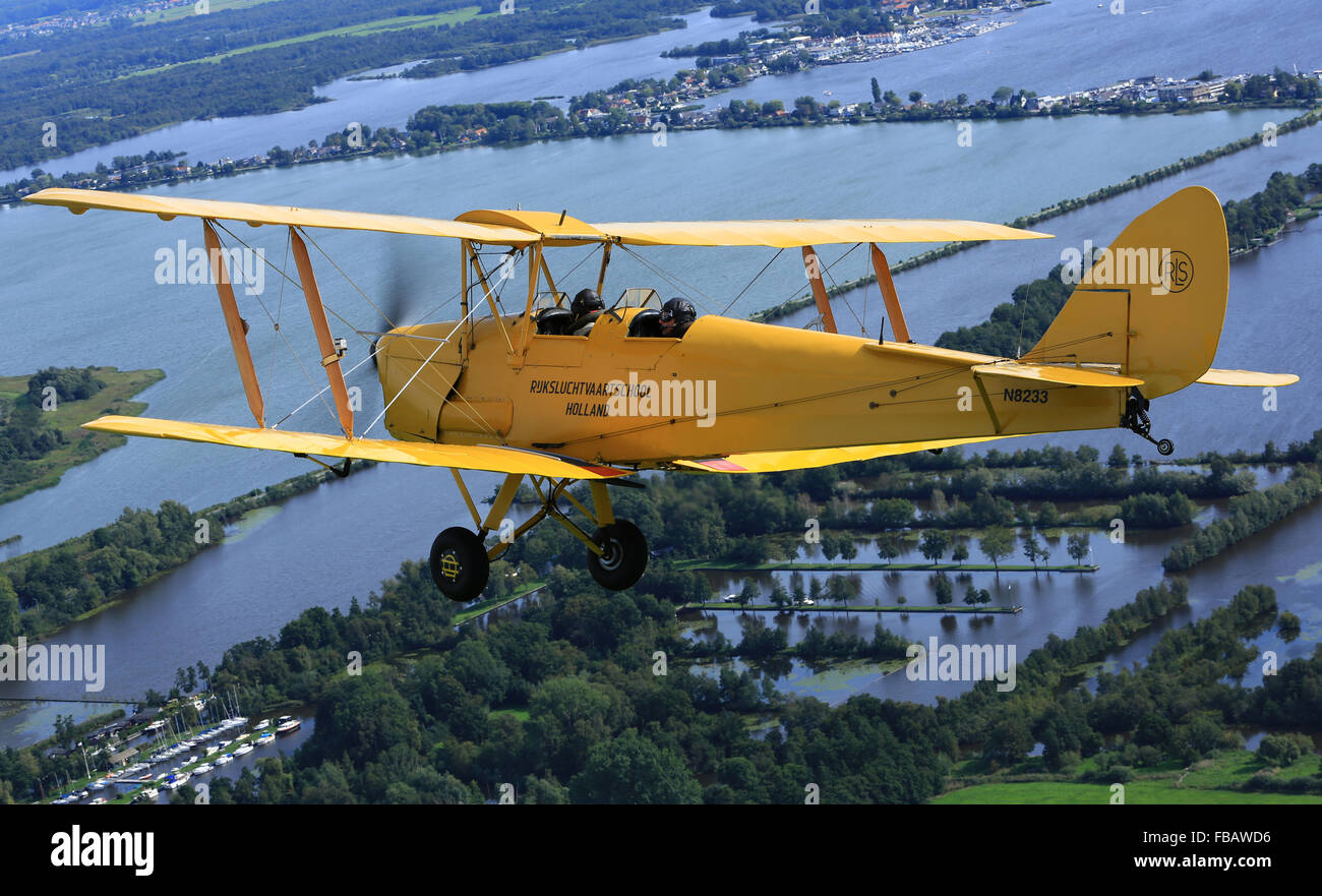 A de Havilland Tiger Moth bi-plane over the Dutch countryside Stock ...