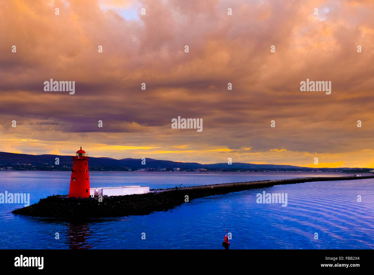 Poolbeg Lighthouse off the coast of Dublin, Ireland at sunset under a ...