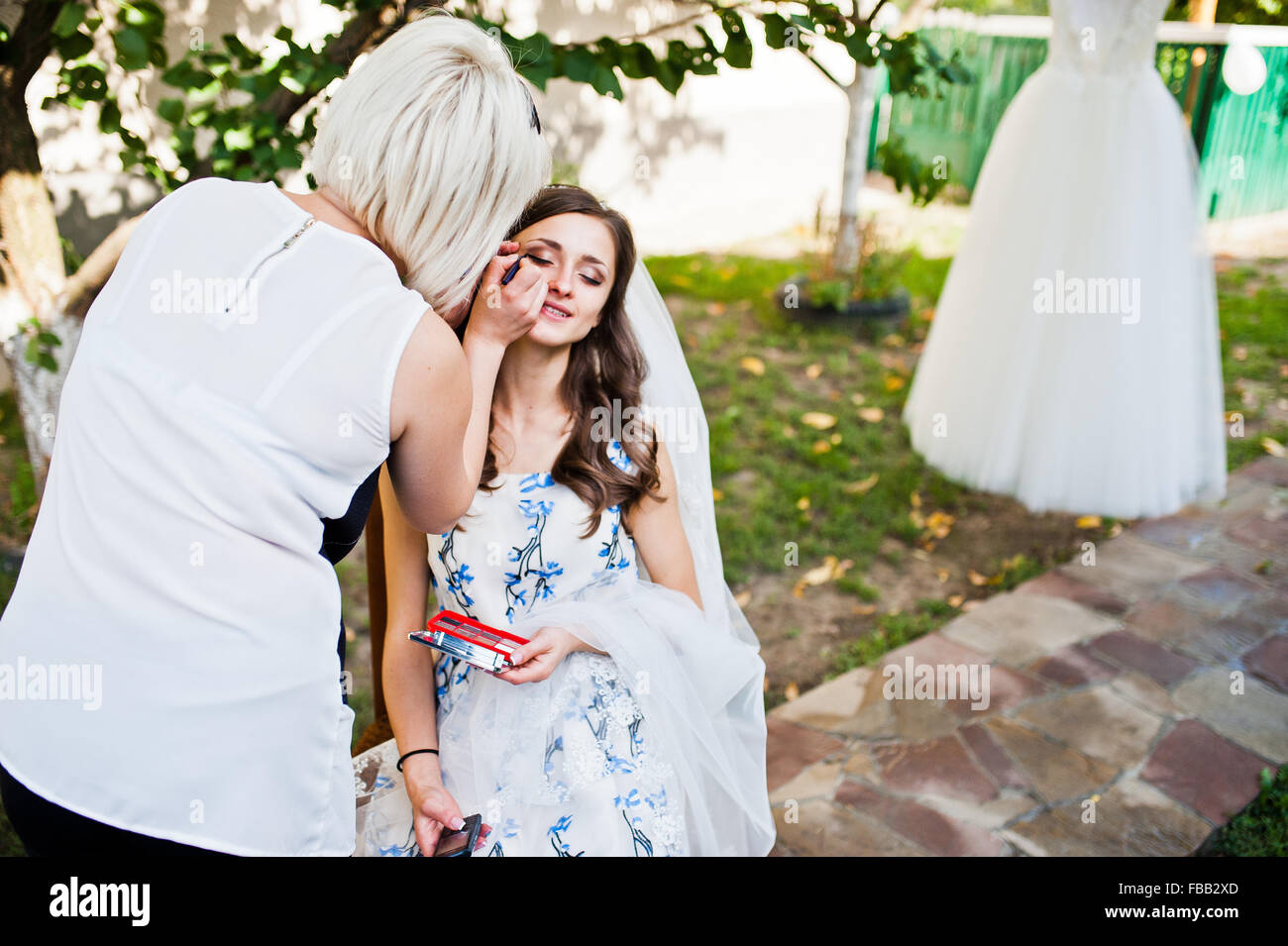 Master makeup artist doing makeup bride outdoors Stock Photo - Alamy
