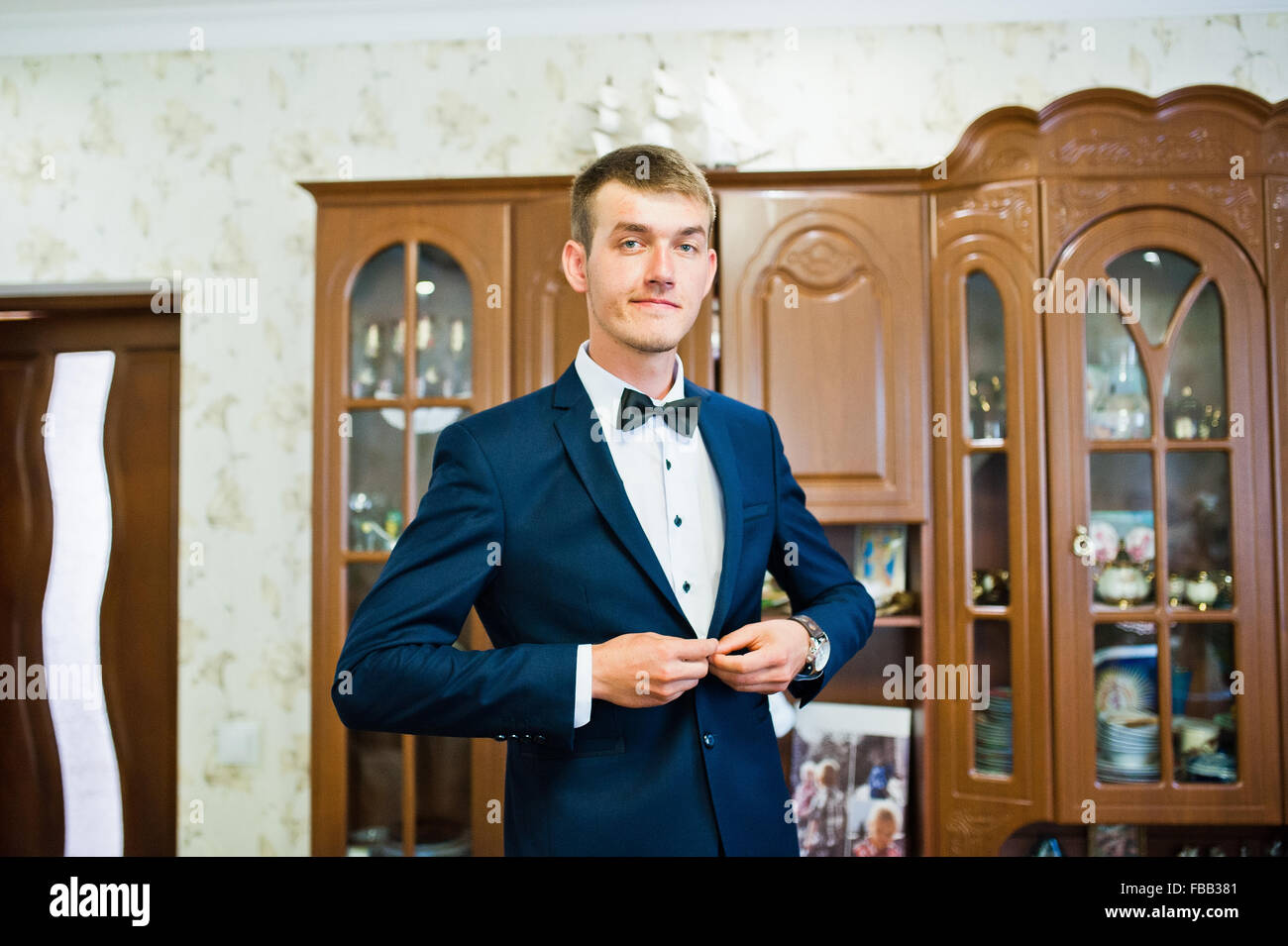 Young groom in his room button buttons on jacket Stock Photo - Alamy