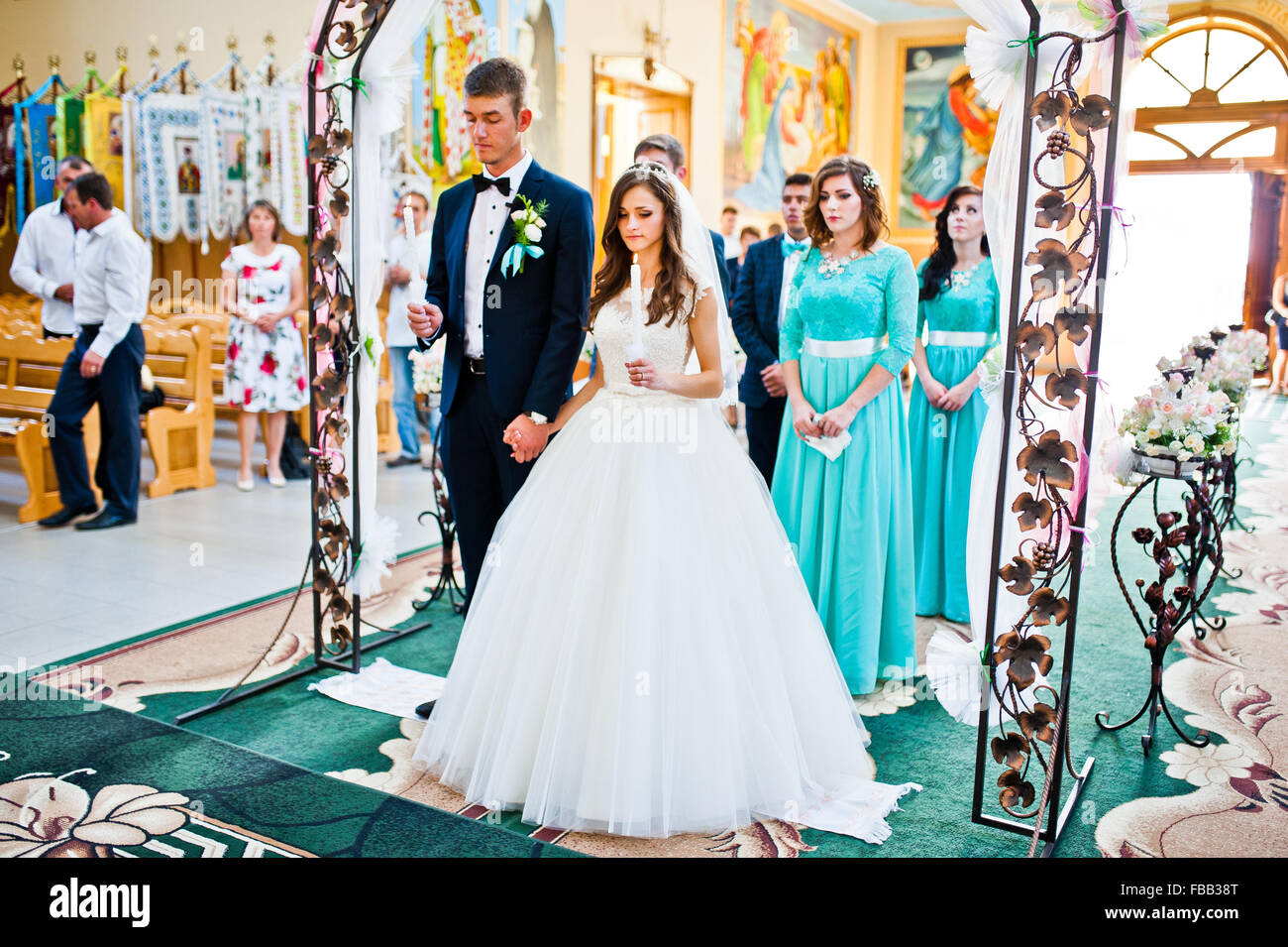 Wedding couple with bridesmaids stay at church under arch Stock Photo ...