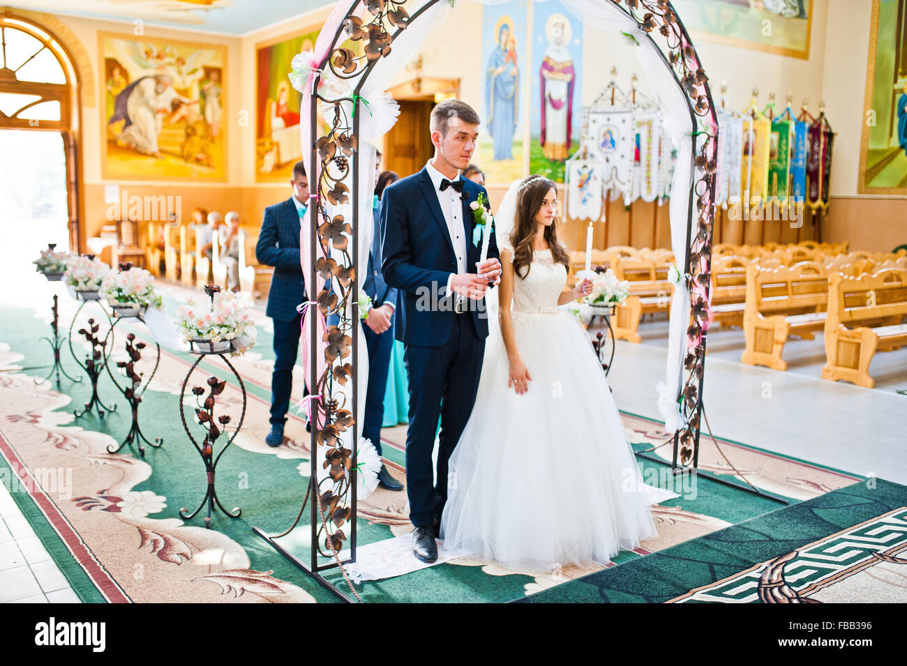 Wedding couple with bridesmaids stay at church under arch Stock Photo ...