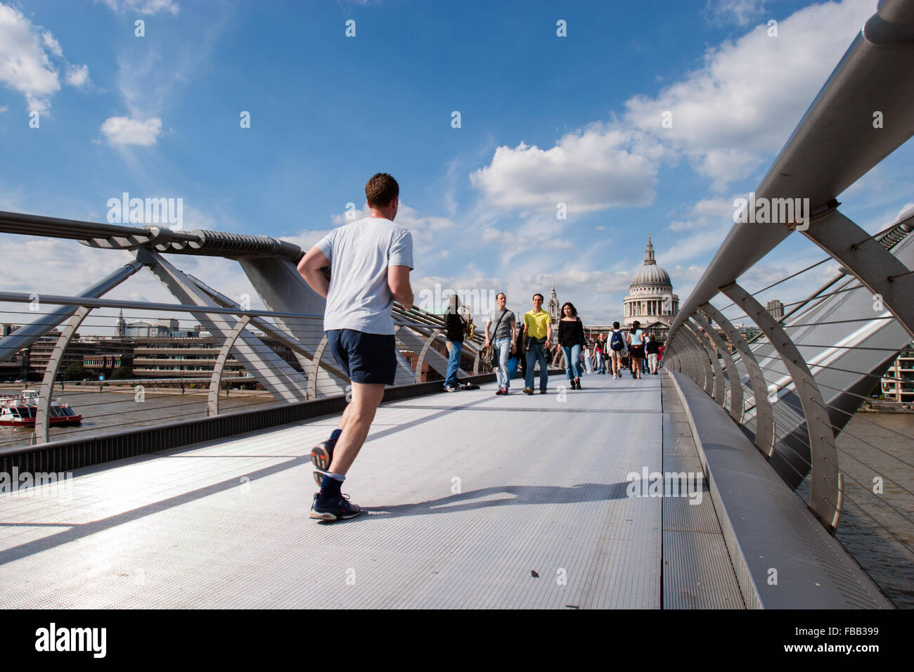 A runner on the Millennium Bridge in London Stock Photo - Alamy