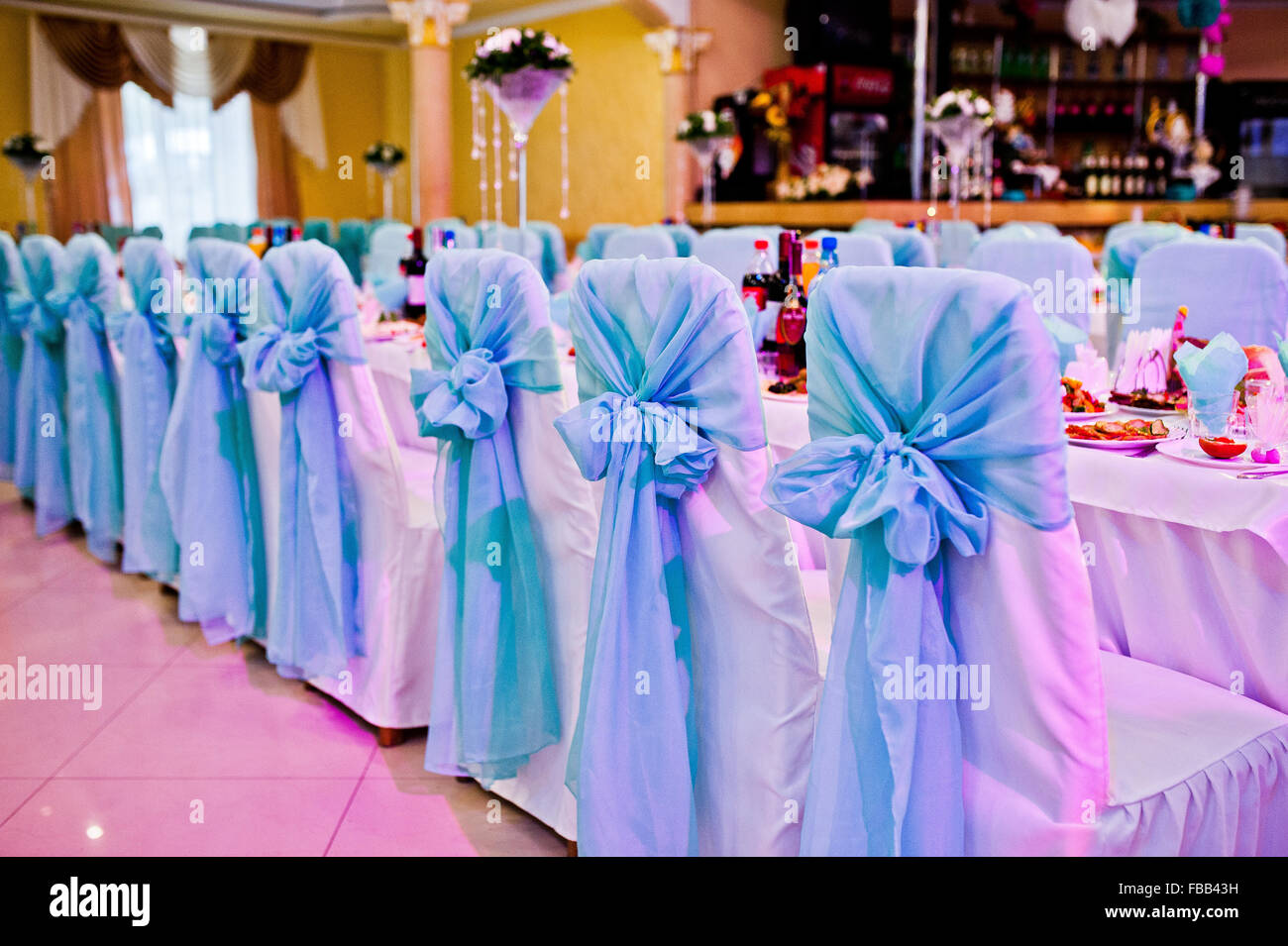 Wedding chairs in a restaurant with turquoise ribbons Stock Photo - Alamy