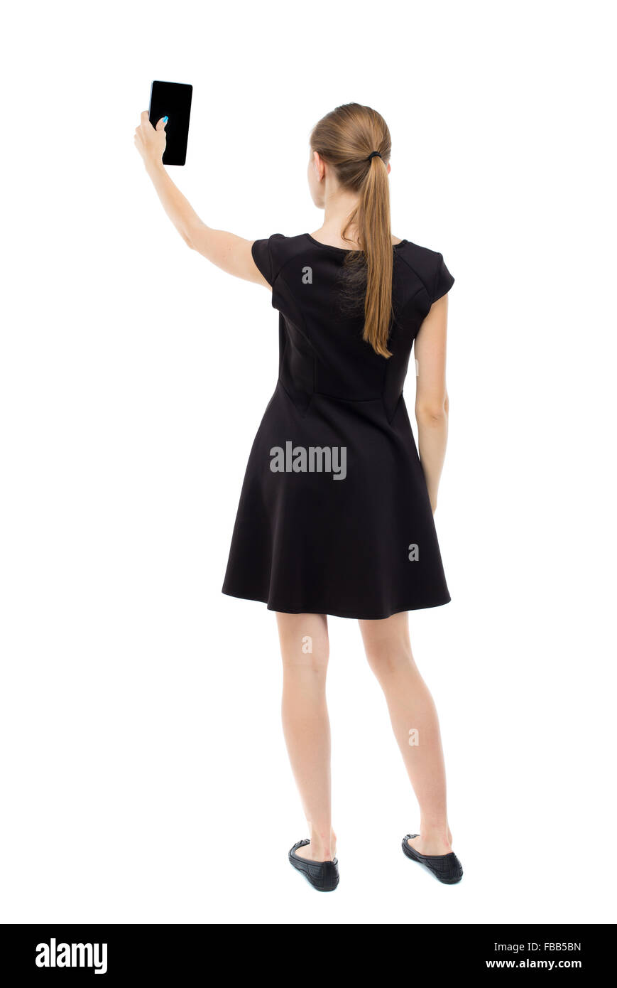 back view of standing young beautiful girl with tablet computer in the ...
