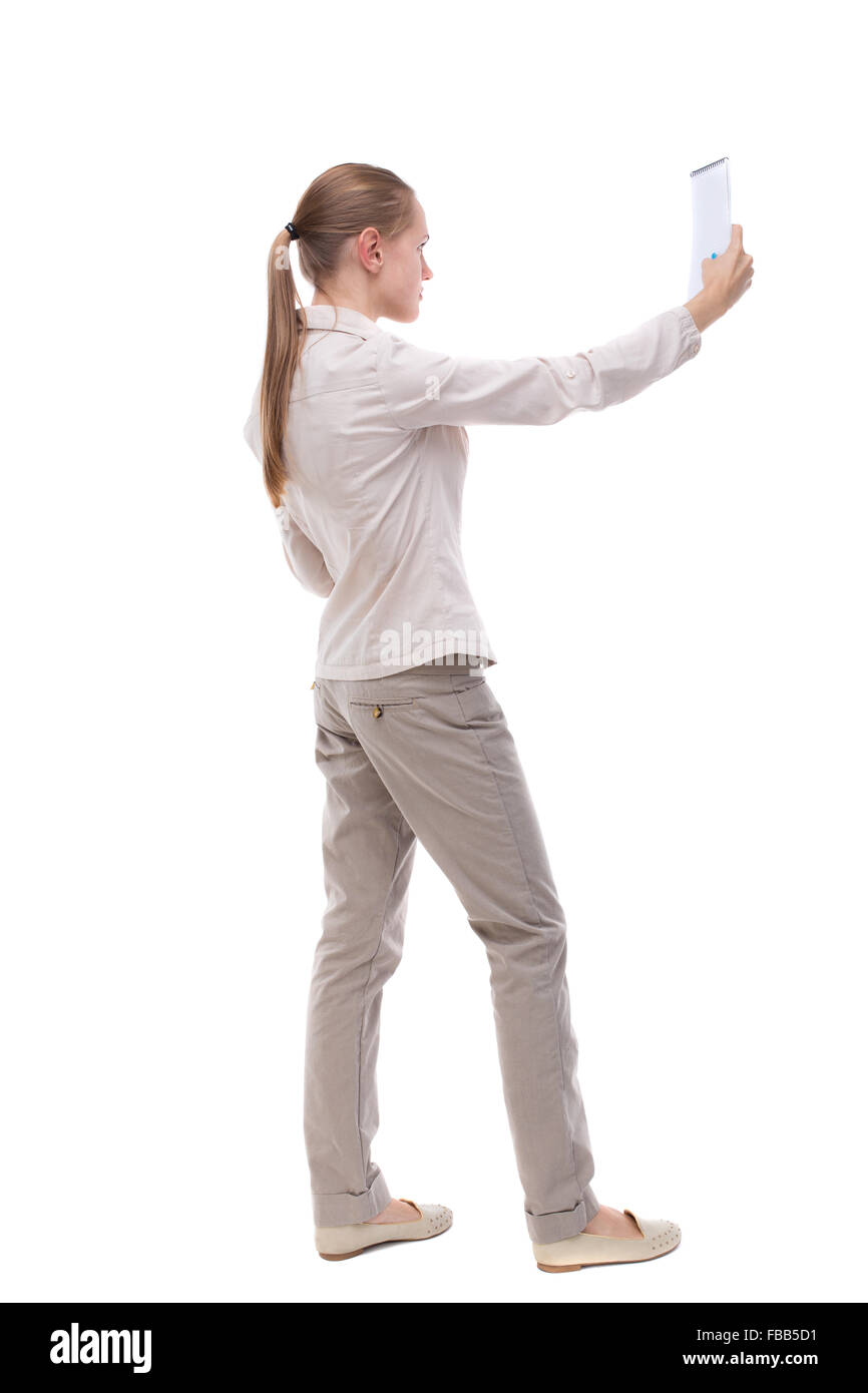 back view of stands woman takes notes in a notebook. girl watching ...