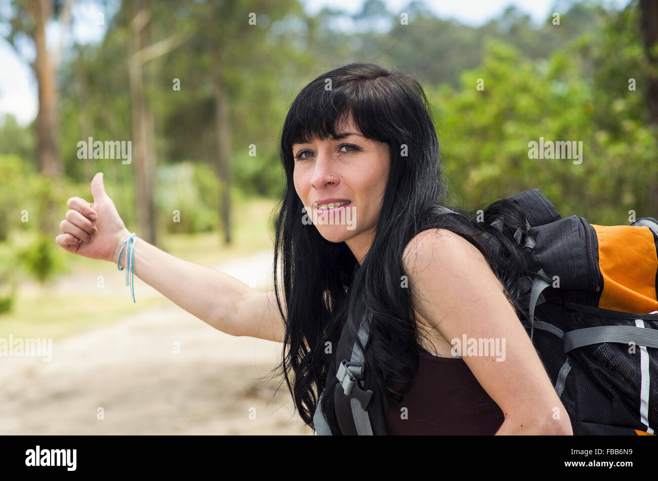 Adventurous brunette, outdoors forest environment wearing backpack ...