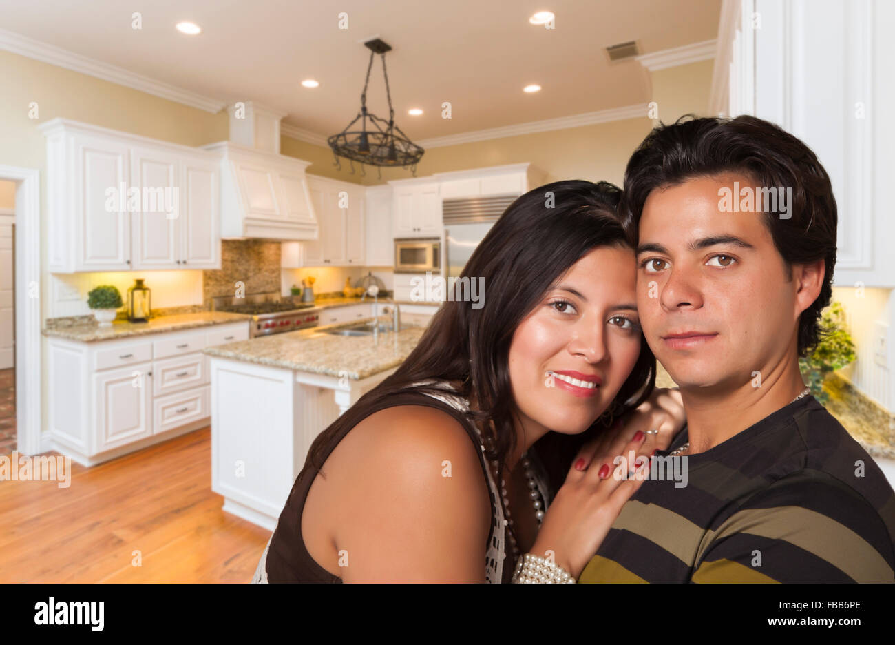 Affectionate Hispanic Couple Inside Custom Kitchen Interior Stock Photo ...