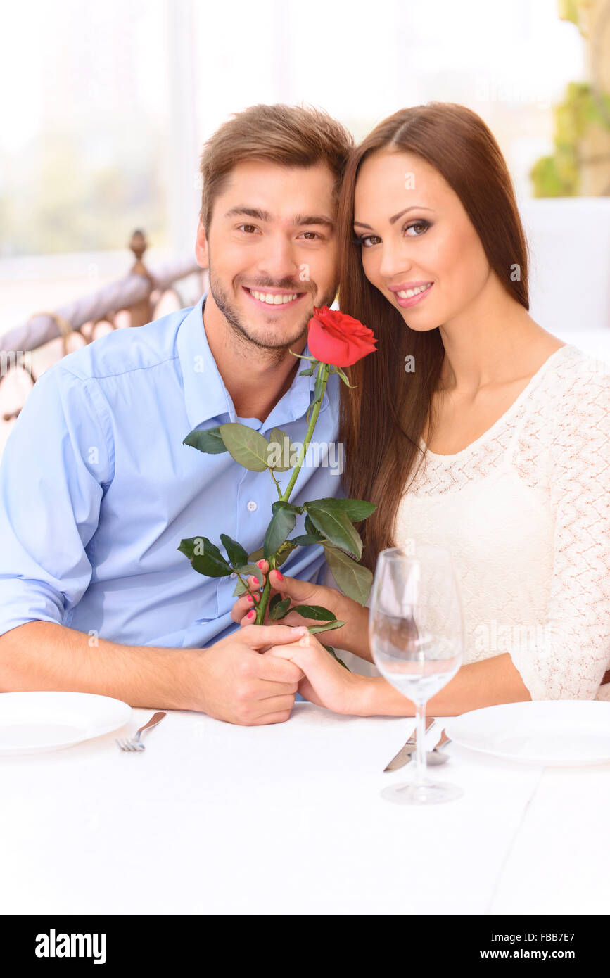 Nice couple sitting at the table Stock Photo - Alamy