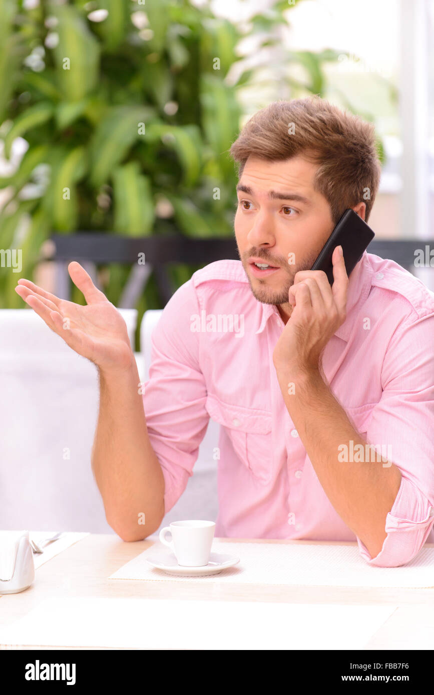 Handsome man sitting at the table Stock Photo - Alamy