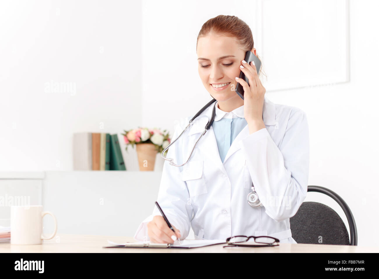 Professional doctor sitting at the table Stock Photo - Alamy