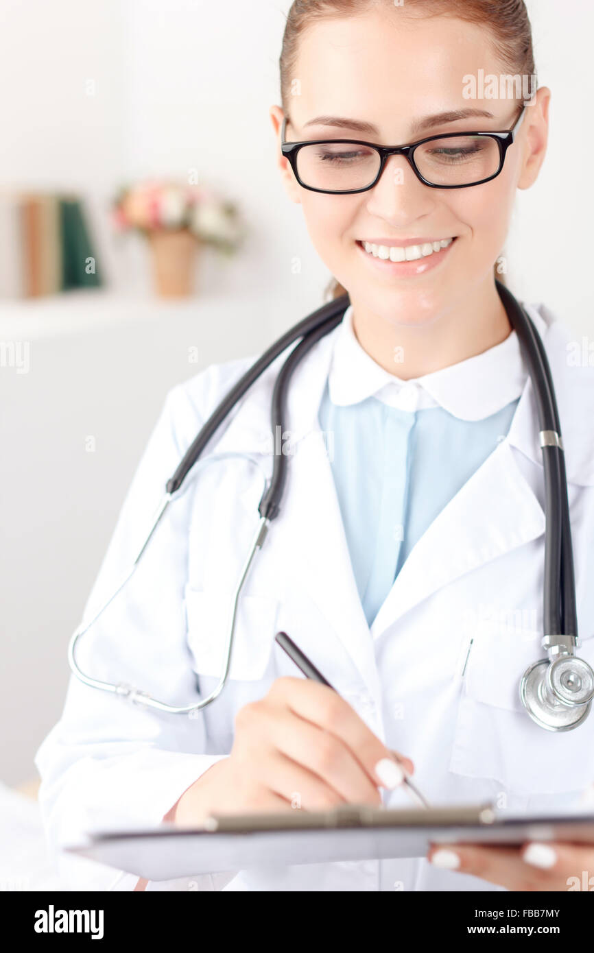 Pretty doctor holding folder Stock Photo - Alamy