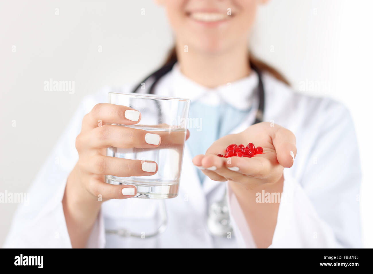 Positive doctor holding pills Stock Photo - Alamy