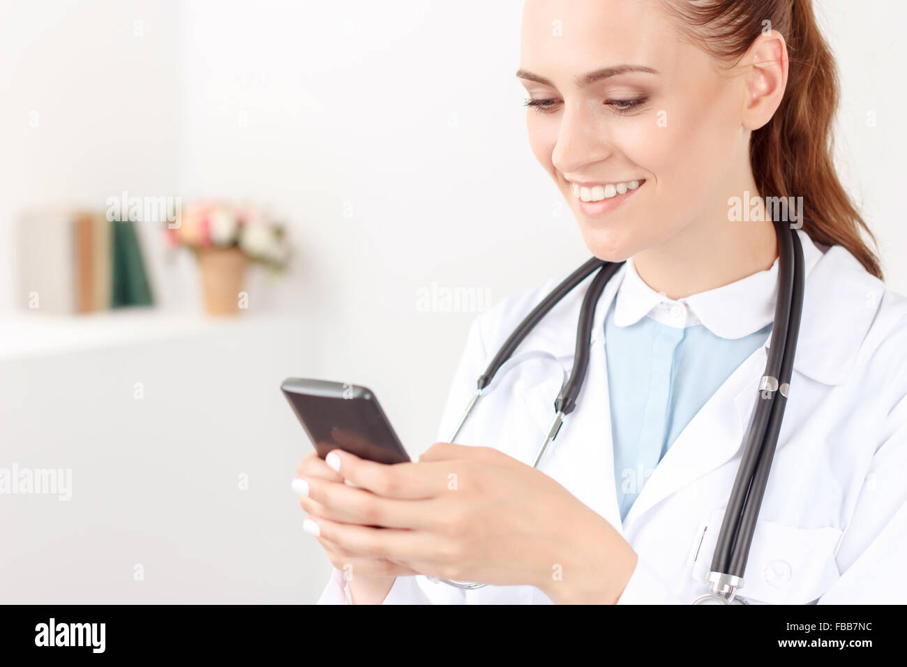 Nice doctor holding mobile phone Stock Photo - Alamy