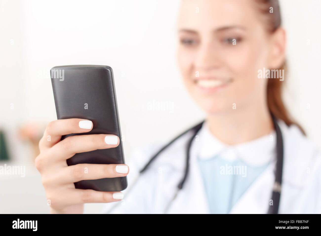 Nice doctor holding mobile phone Stock Photo - Alamy