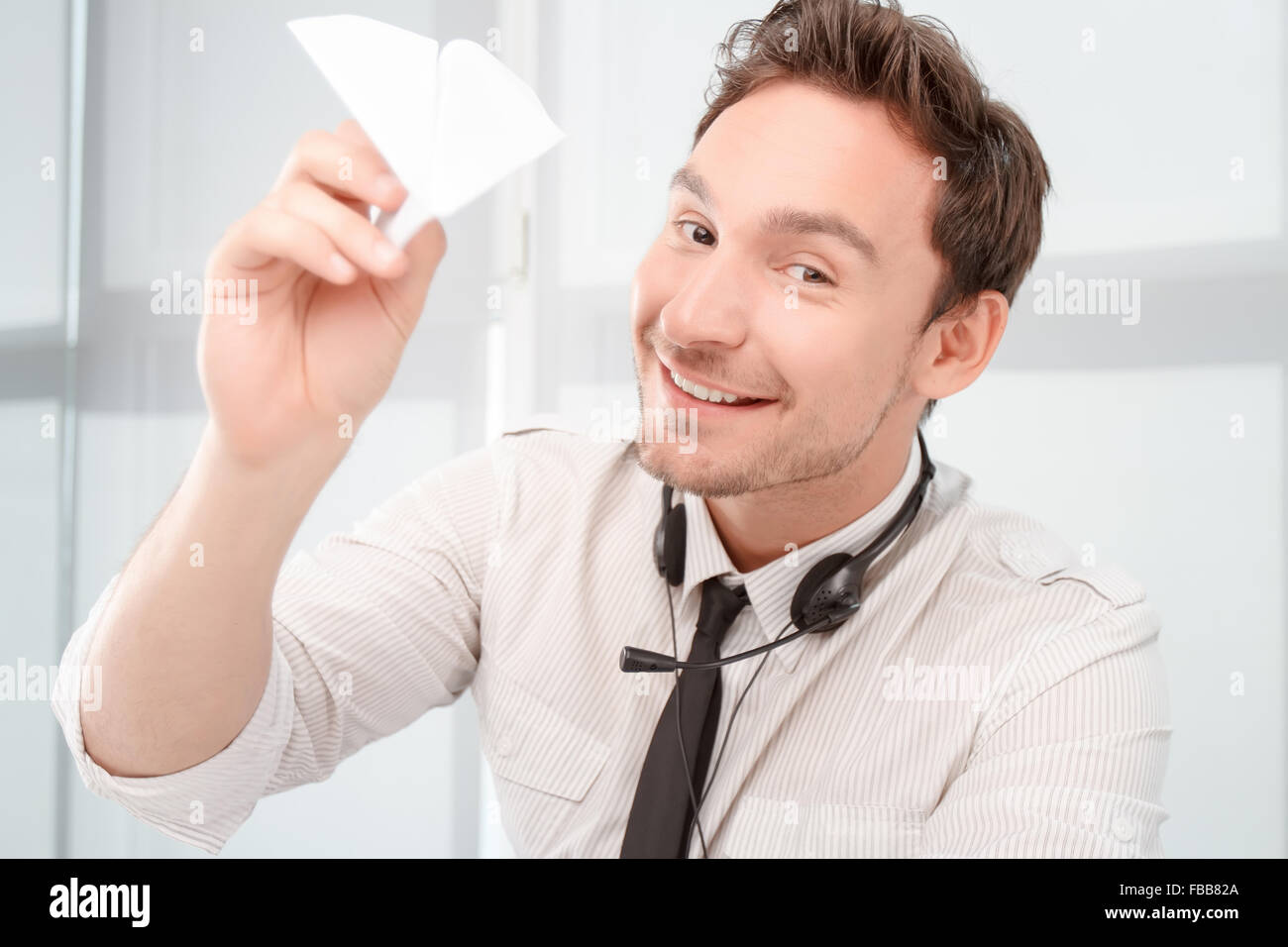 Positive call center operator holding paper plane Stock Photo - Alamy