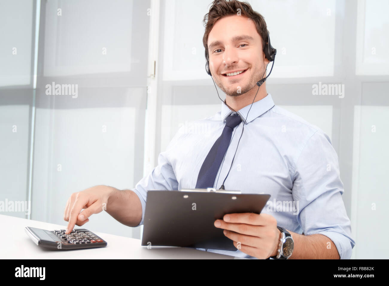 Call center operator counting on calculator Stock Photo - Alamy