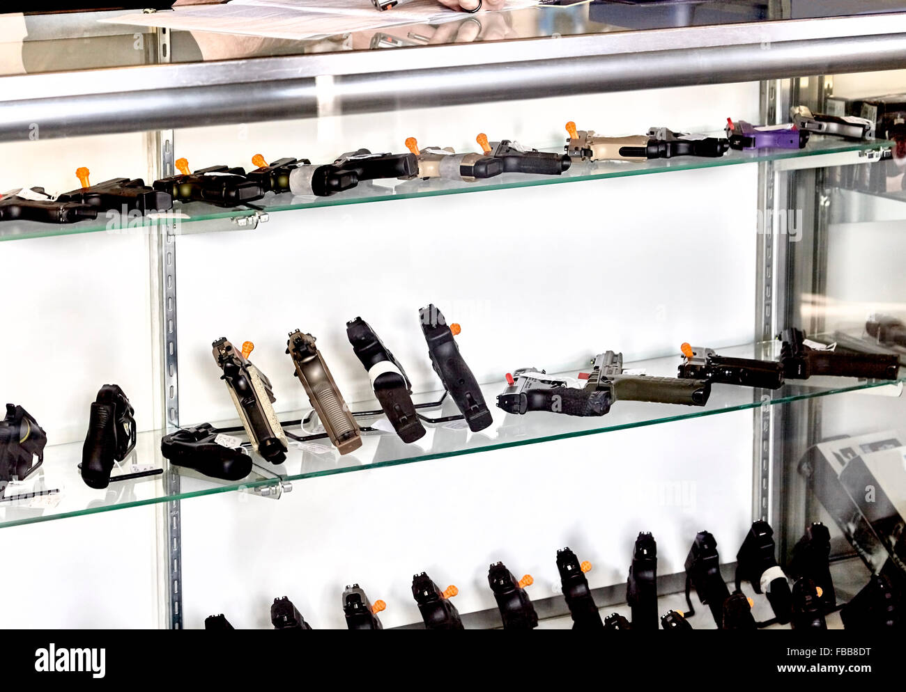 Rows of guns for sale in showcase of retail store with application on ...