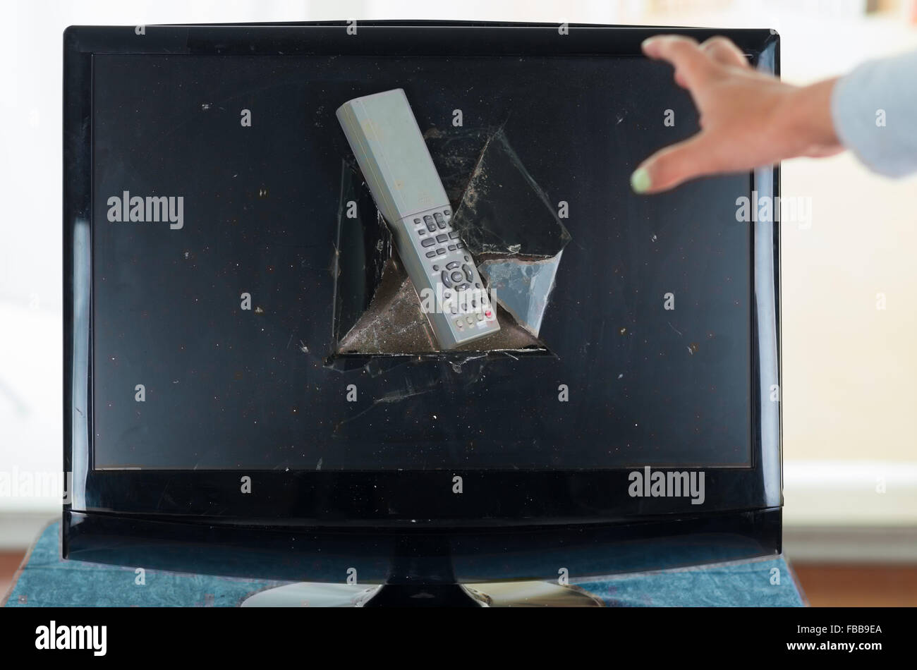 Remote control stuck inside broken computer screen Stock Photo - Alamy