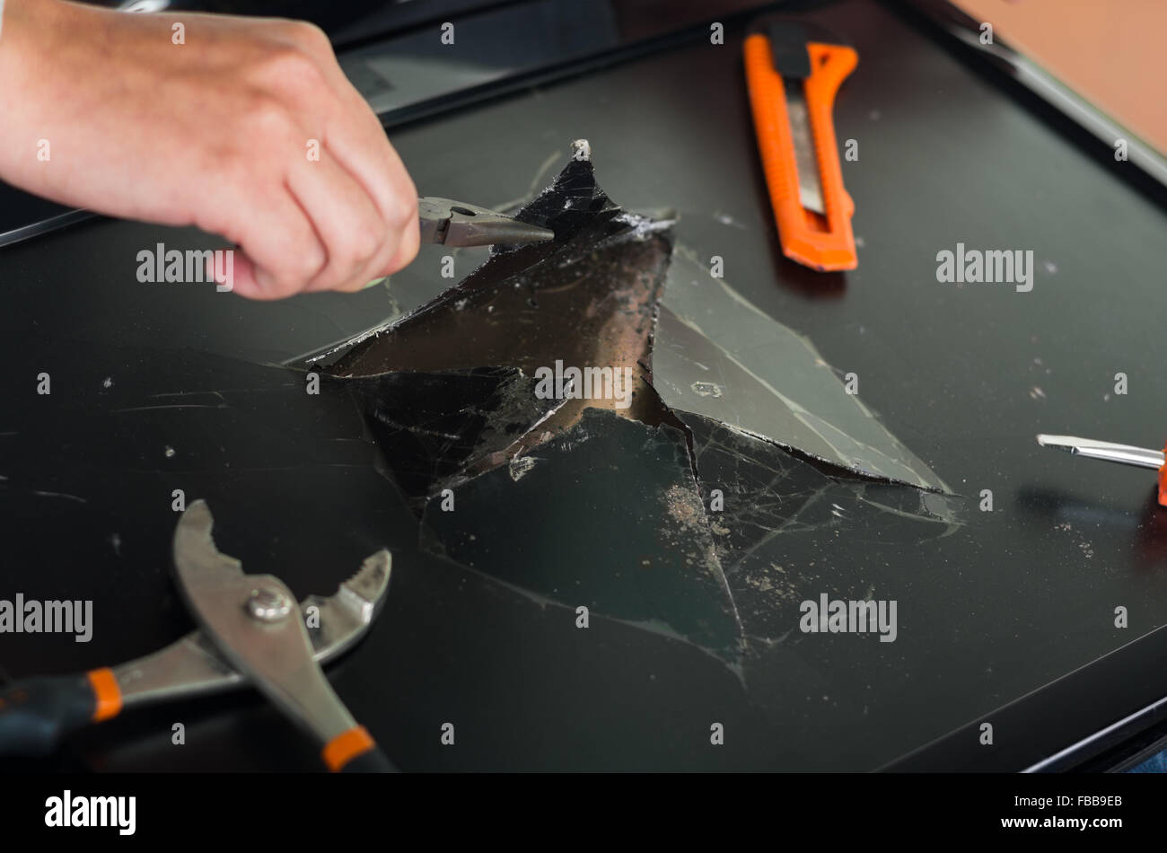 Hands working on broken computer screen using different tools Stock ...