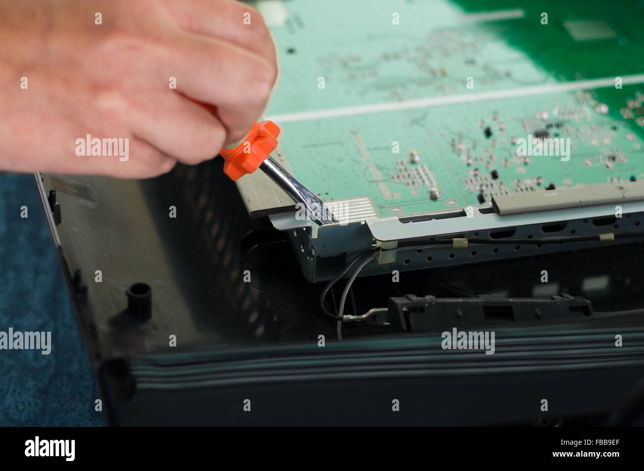 Hands working with electronic circuit board from broken computer screen ...
