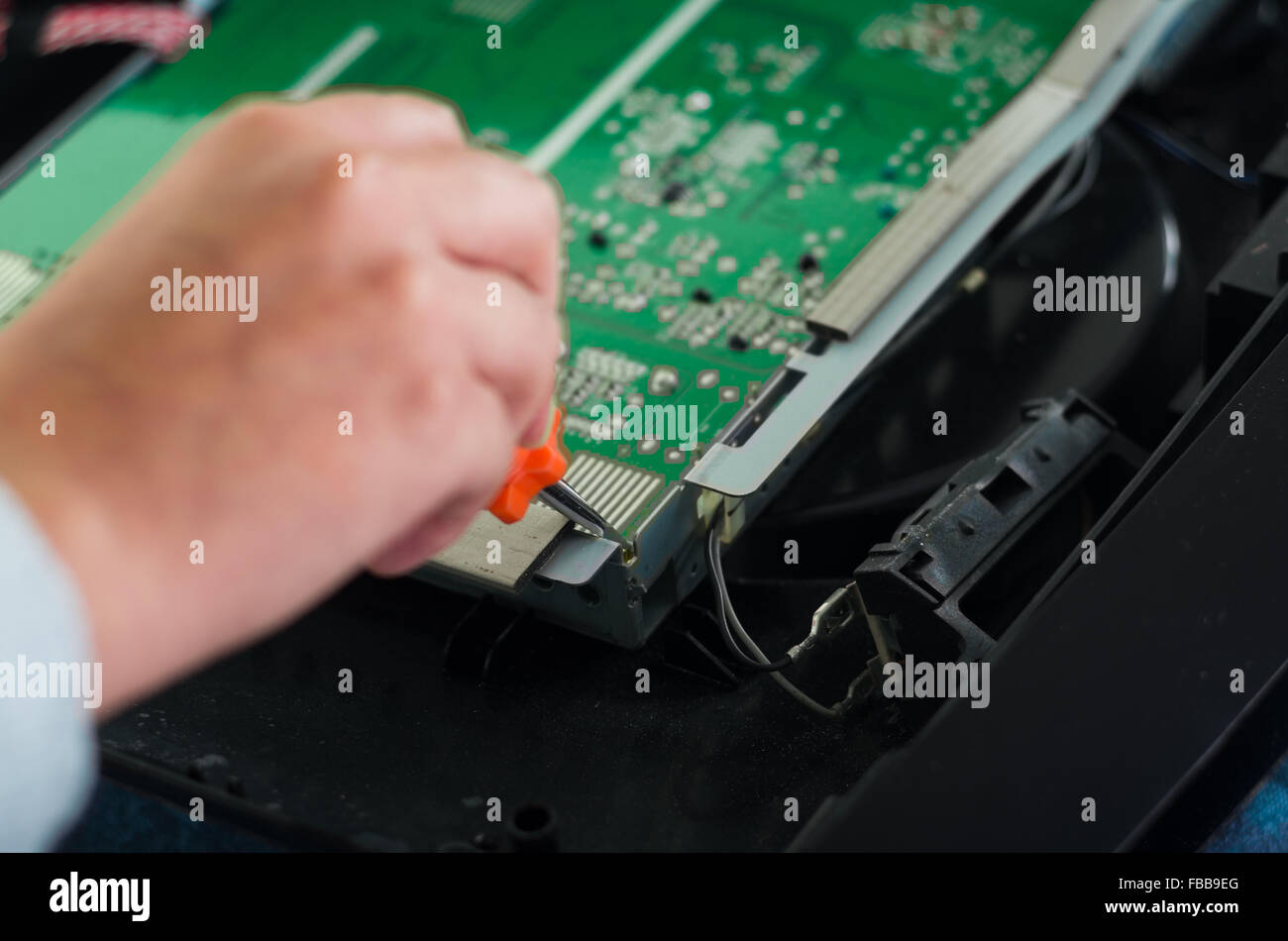 Hands working with electronic circuit board from broken computer screen ...