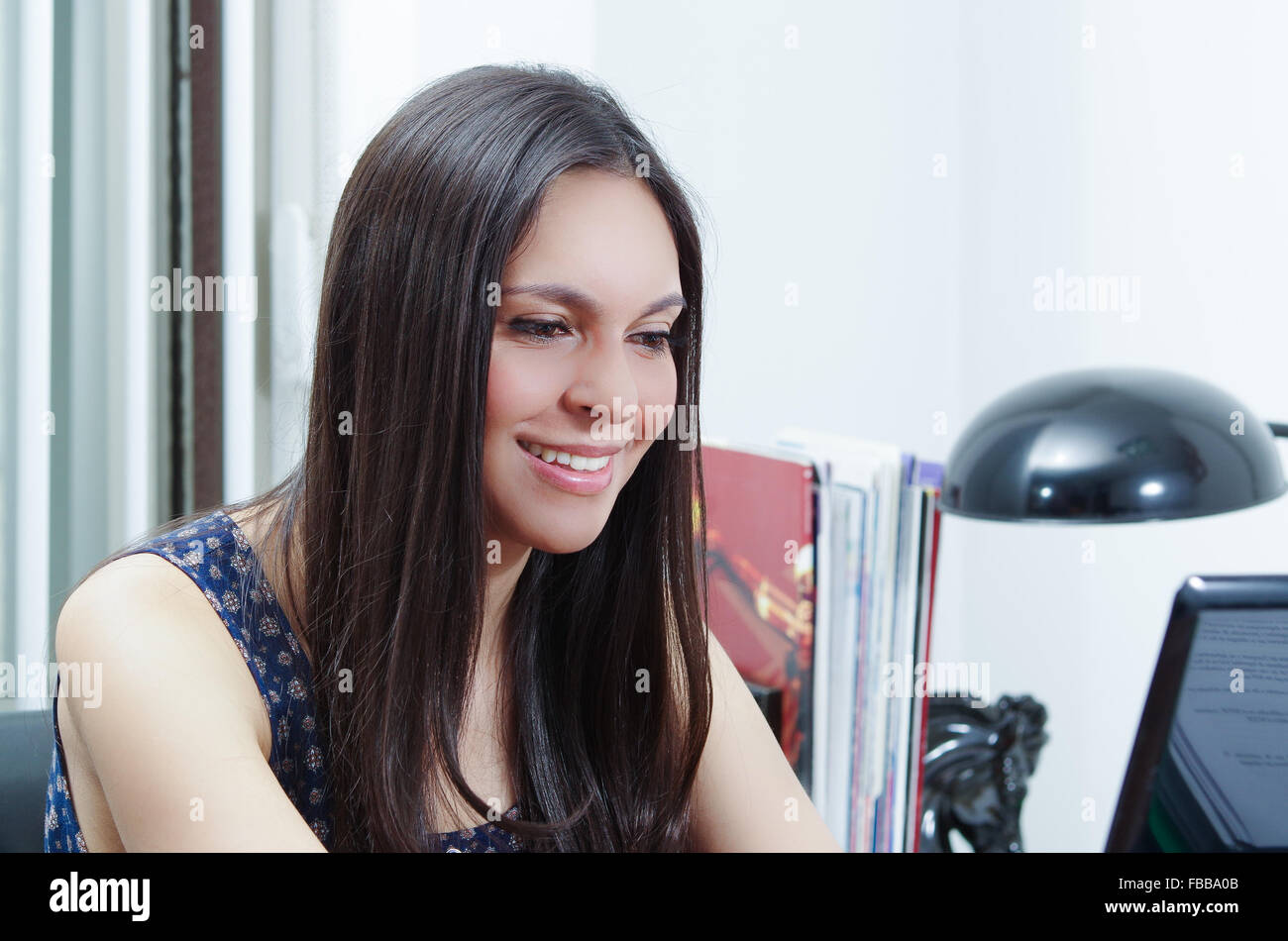 Hispanic brunette office woman sitting by desk and working on computer ...