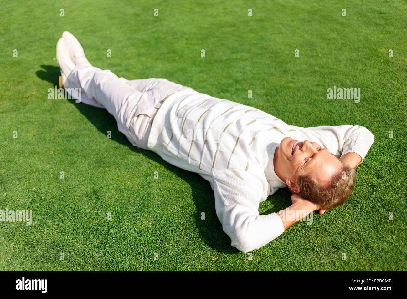 Agreeable man lying on the grass Stock Photo - Alamy