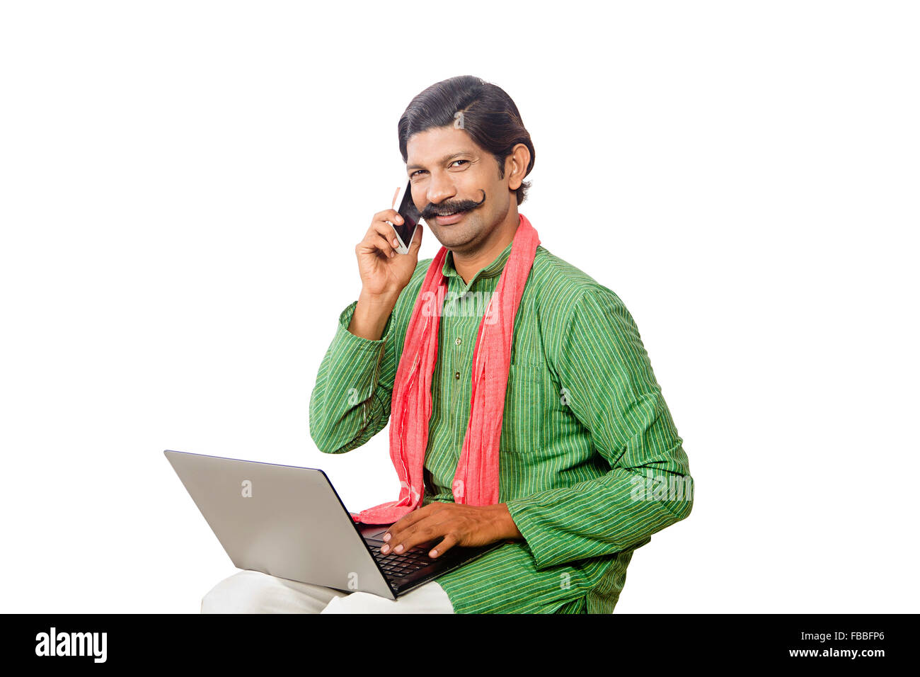 1 indian Rural man sitting laptop and talking Mobile Phone Multi ...