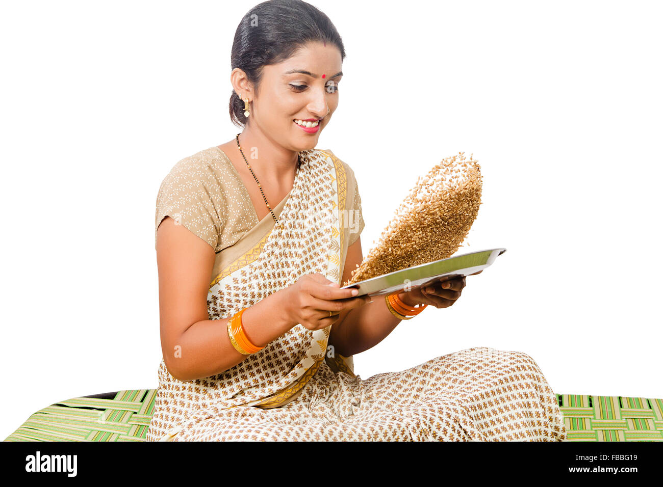 1 indian Rural villager woman sitting Charpai and Cleaning Wheat Stock ...