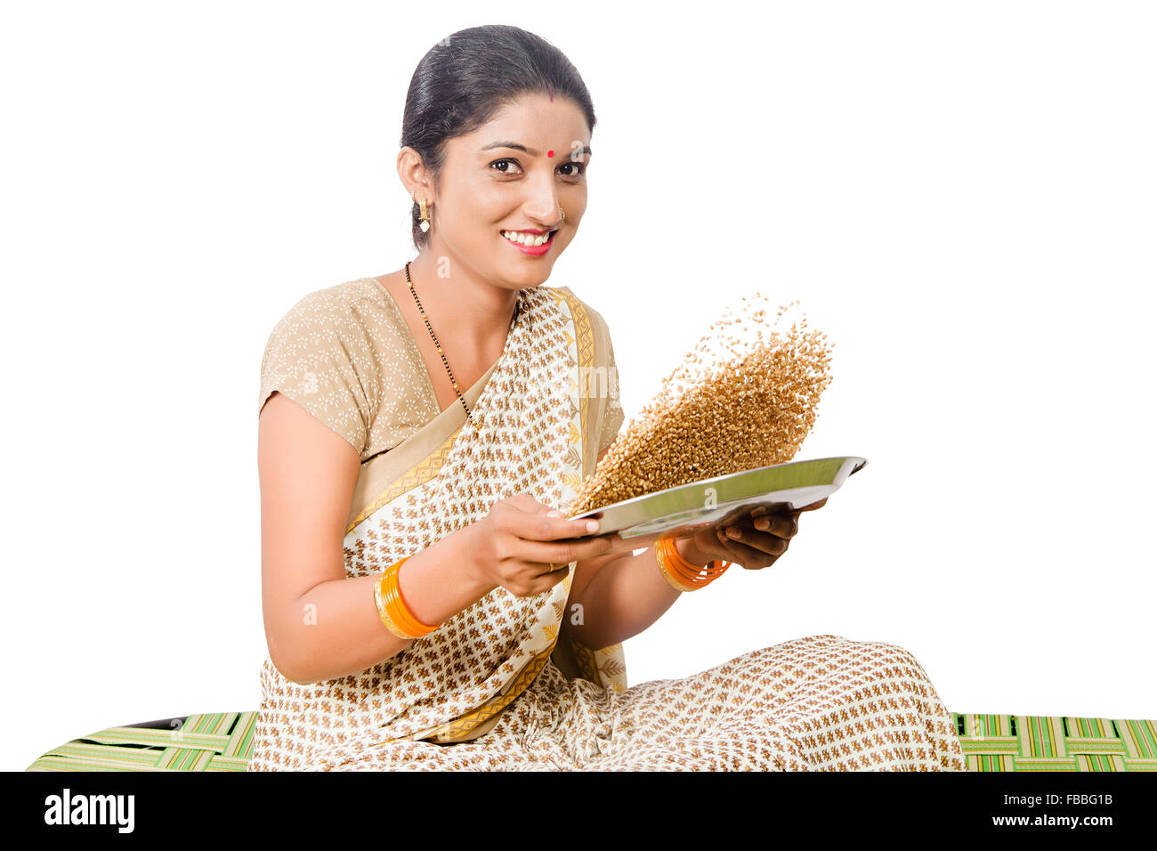 1 indian Rural villager woman sitting Charpai and Cleaning Wheat Stock ...
