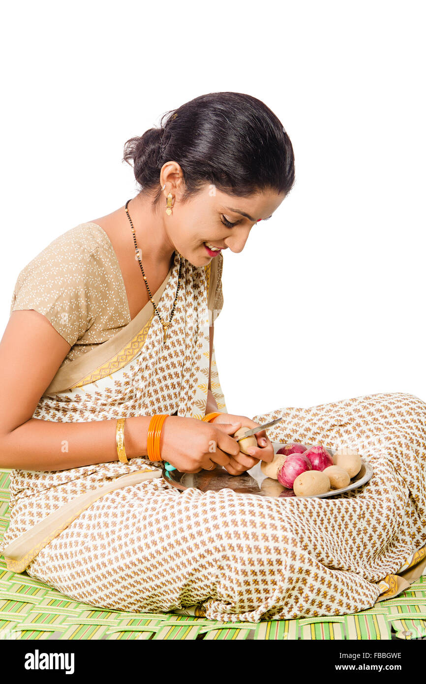 1 indian Rural villager woman sitting Charpai and Cutting Vegetable ...