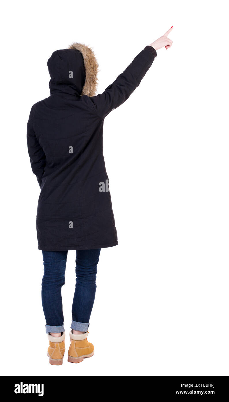 Back view of pointing young women in parka. Young girl gesture. Rear ...
