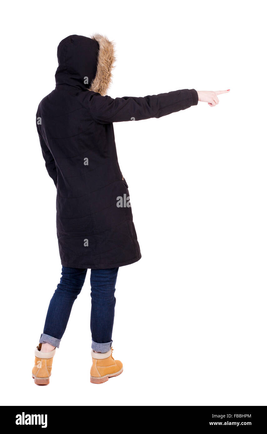 Back view of pointing young women in parka. Young girl gesture. Rear ...