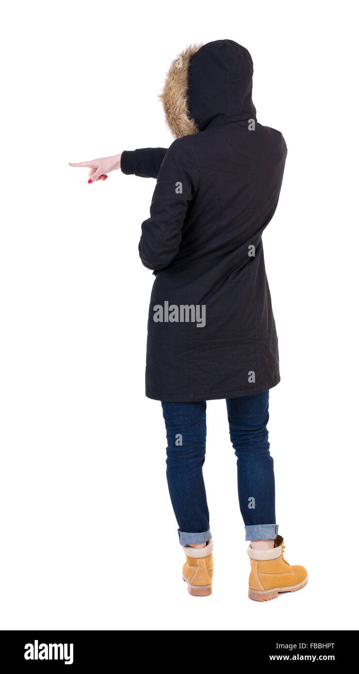 Back view of pointing young women in parka. Young girl gesture. Rear ...