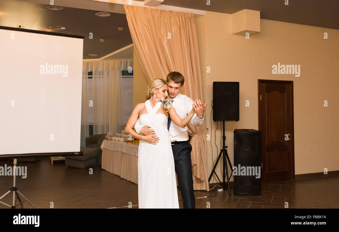 beautiful caucasian couple just married and dancing their first dance ...