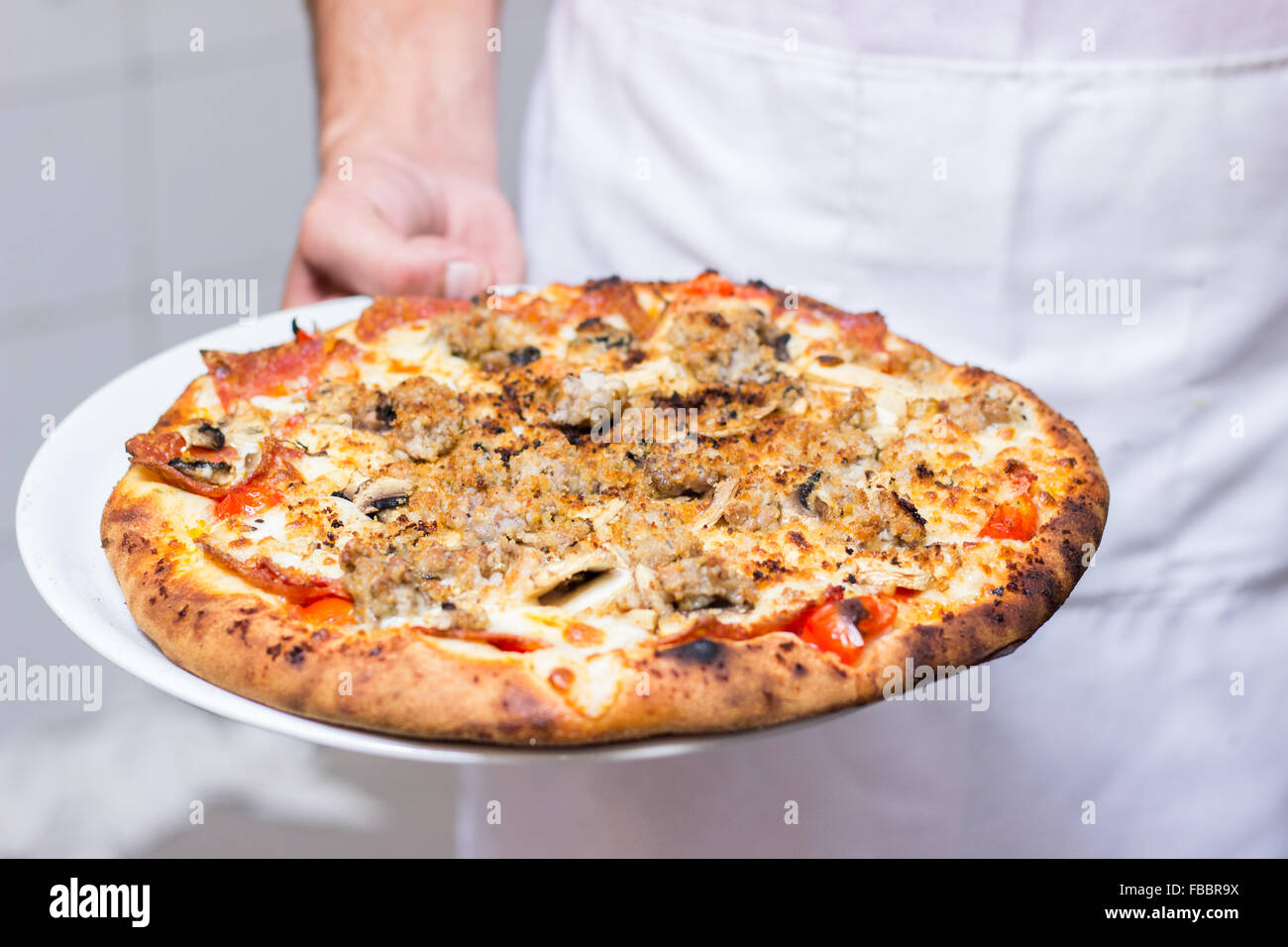 pizza plate cook holding cooked restaurant close up Stock Photo - Alamy