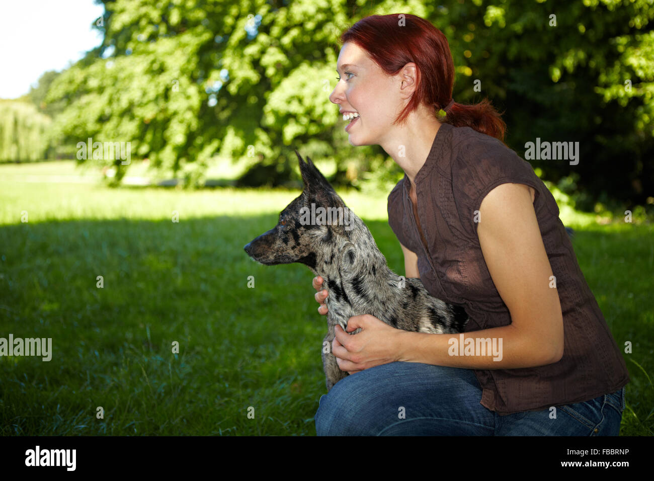 Happy woman with her dog in a park Stock Photo - Alamy