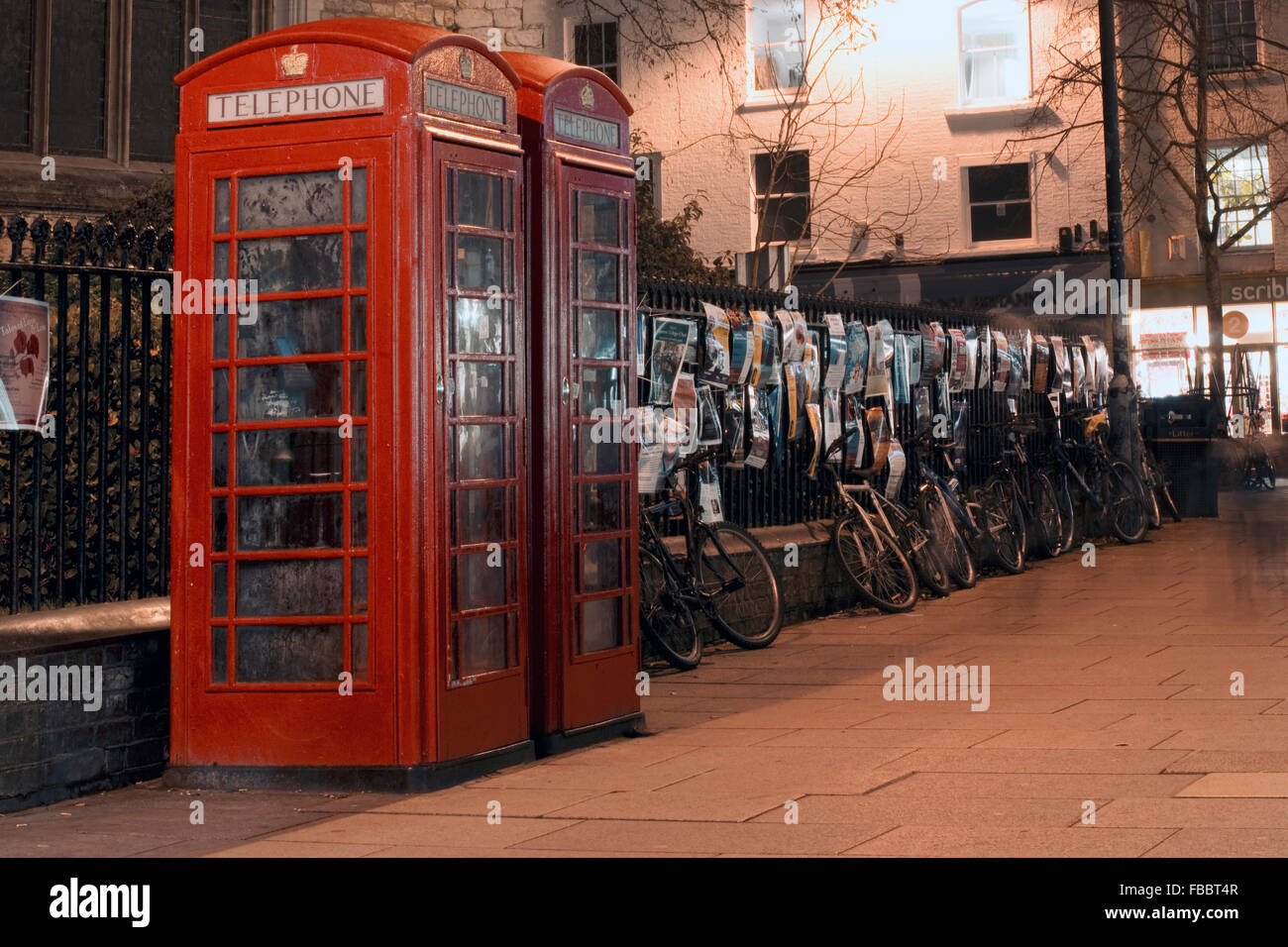 Red old style telephone phone boxes in Cambridge with posters on iron ...
