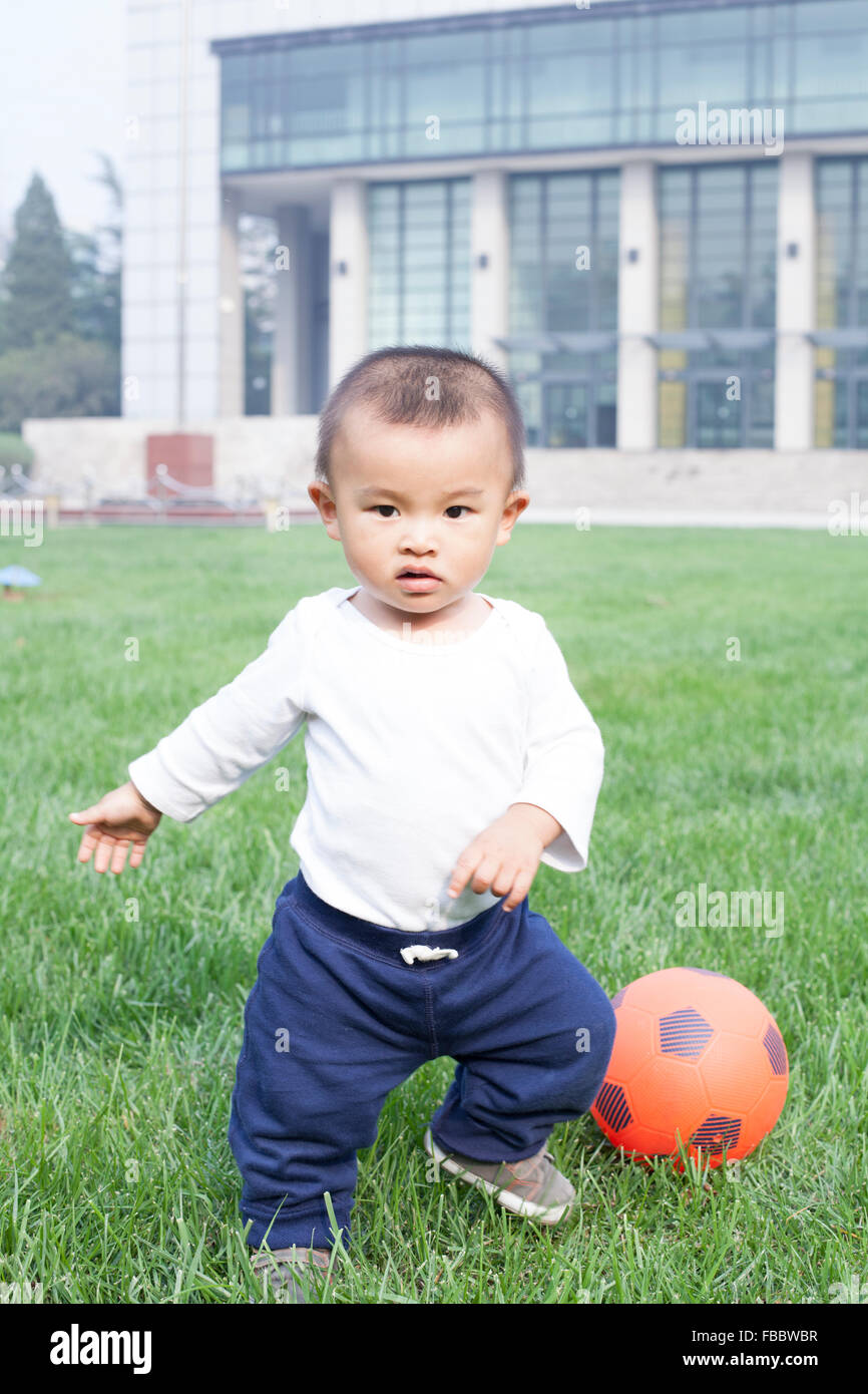 Chinese baby boy playing soccer in meadow, shot in Beijing, China Stock ...