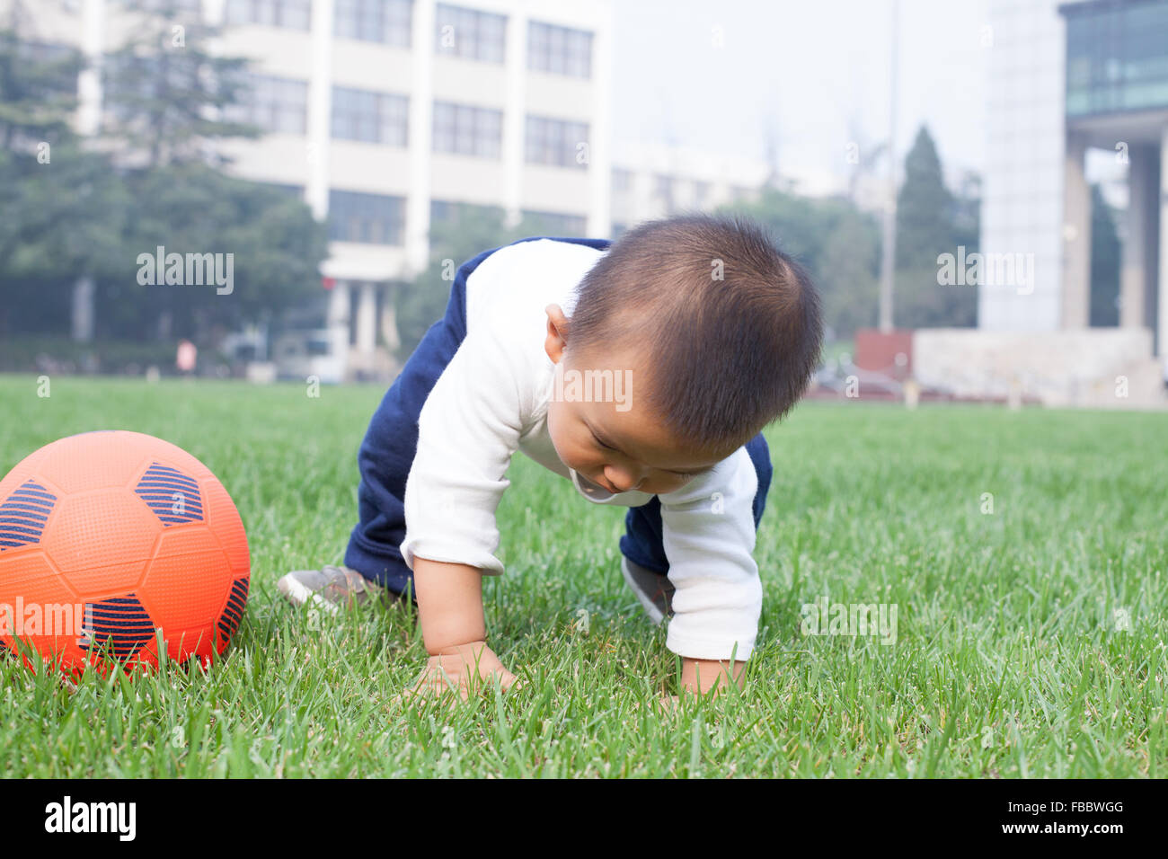 Chinese baby boy with a soccer ball in grass, shot in Beijing, China ...