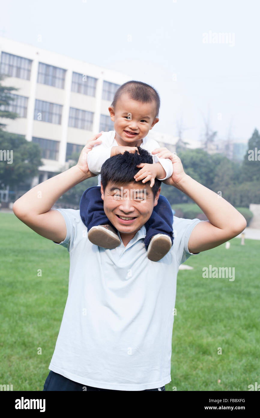 Happy Chinese father carrying his son on his shoulders, shot in Beijing ...