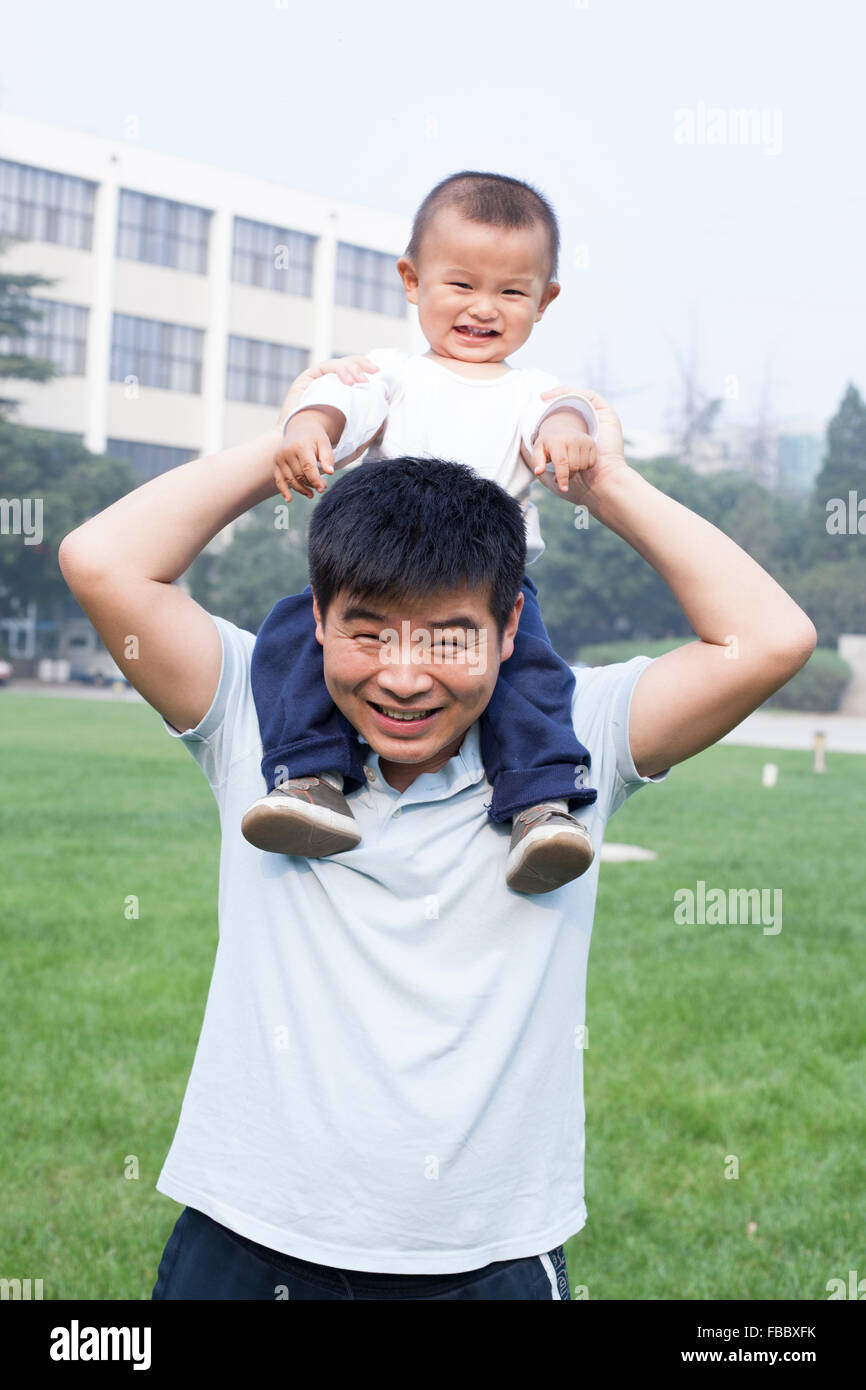 Happy Chinese father carrying his son on his shoulders, shot in Beijing ...