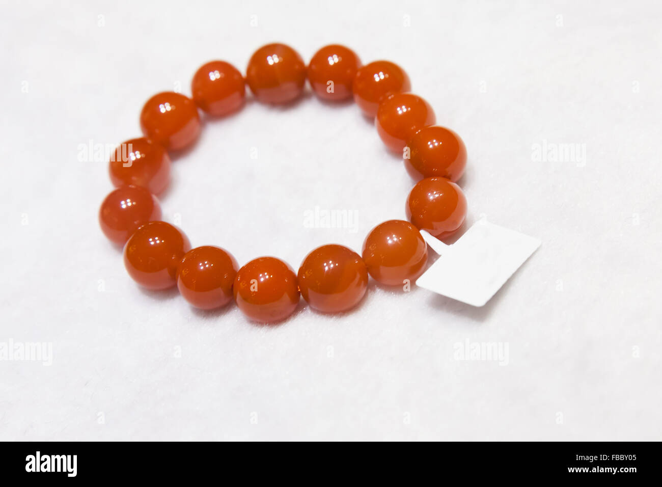 Chinese bracelet made of red round agate stones lays on white counter ...
