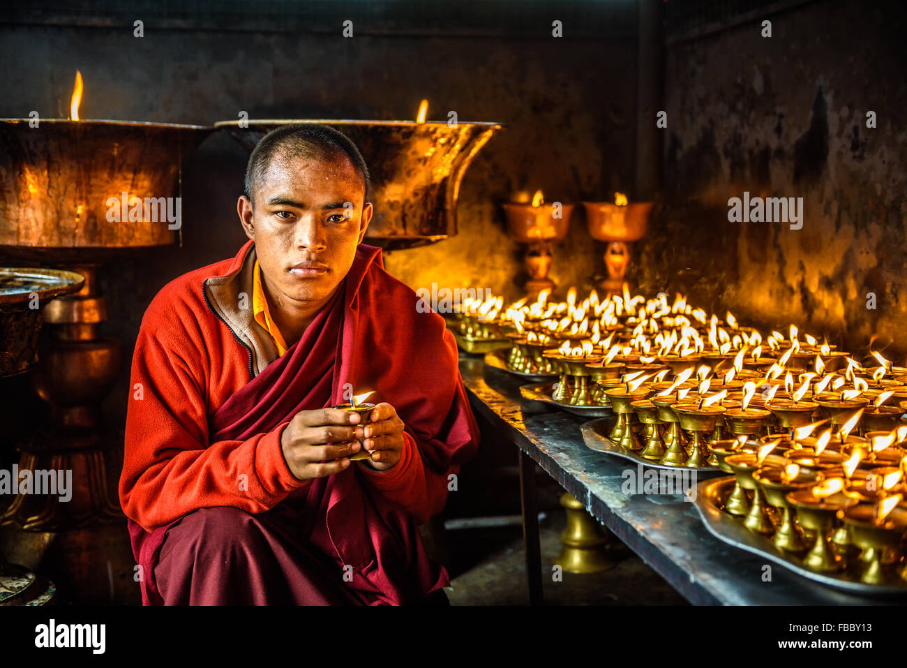 Buddhist monk lighting up candlelight inside a buddhist temple in ...