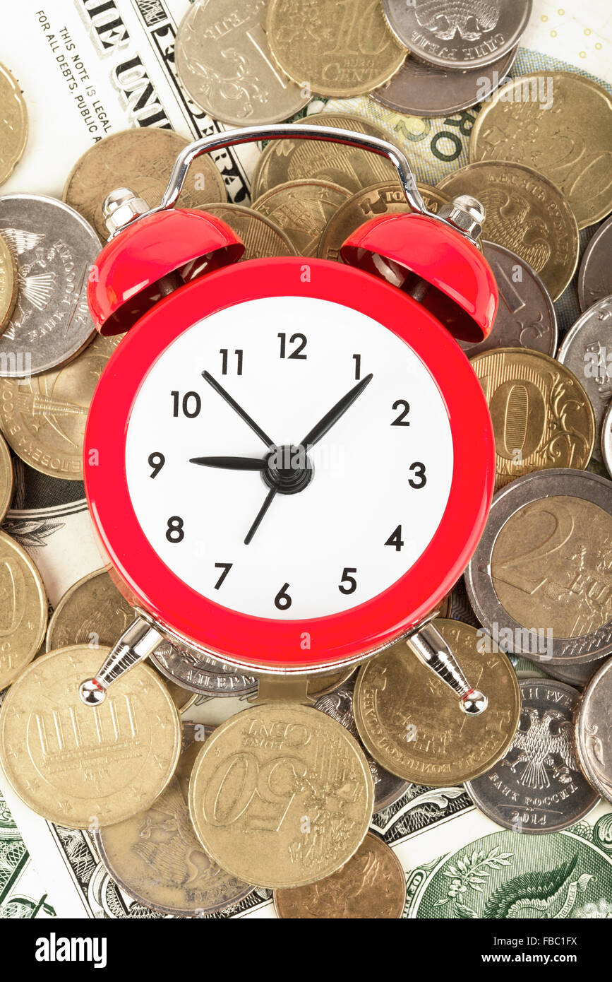 Red alarm clock on cash Stock Photo - Alamy