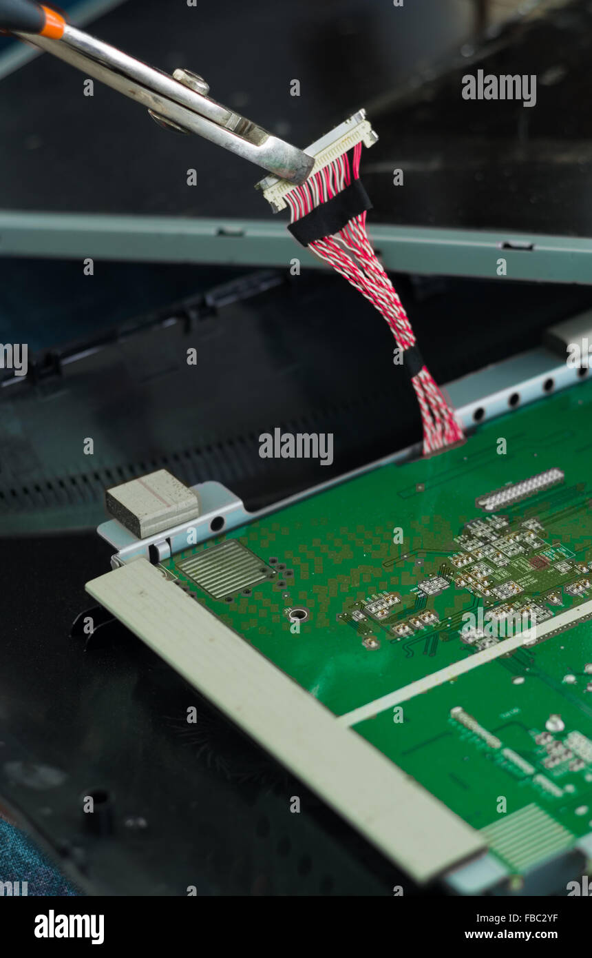 Hands working with electronic circuit board from broken computer screen ...