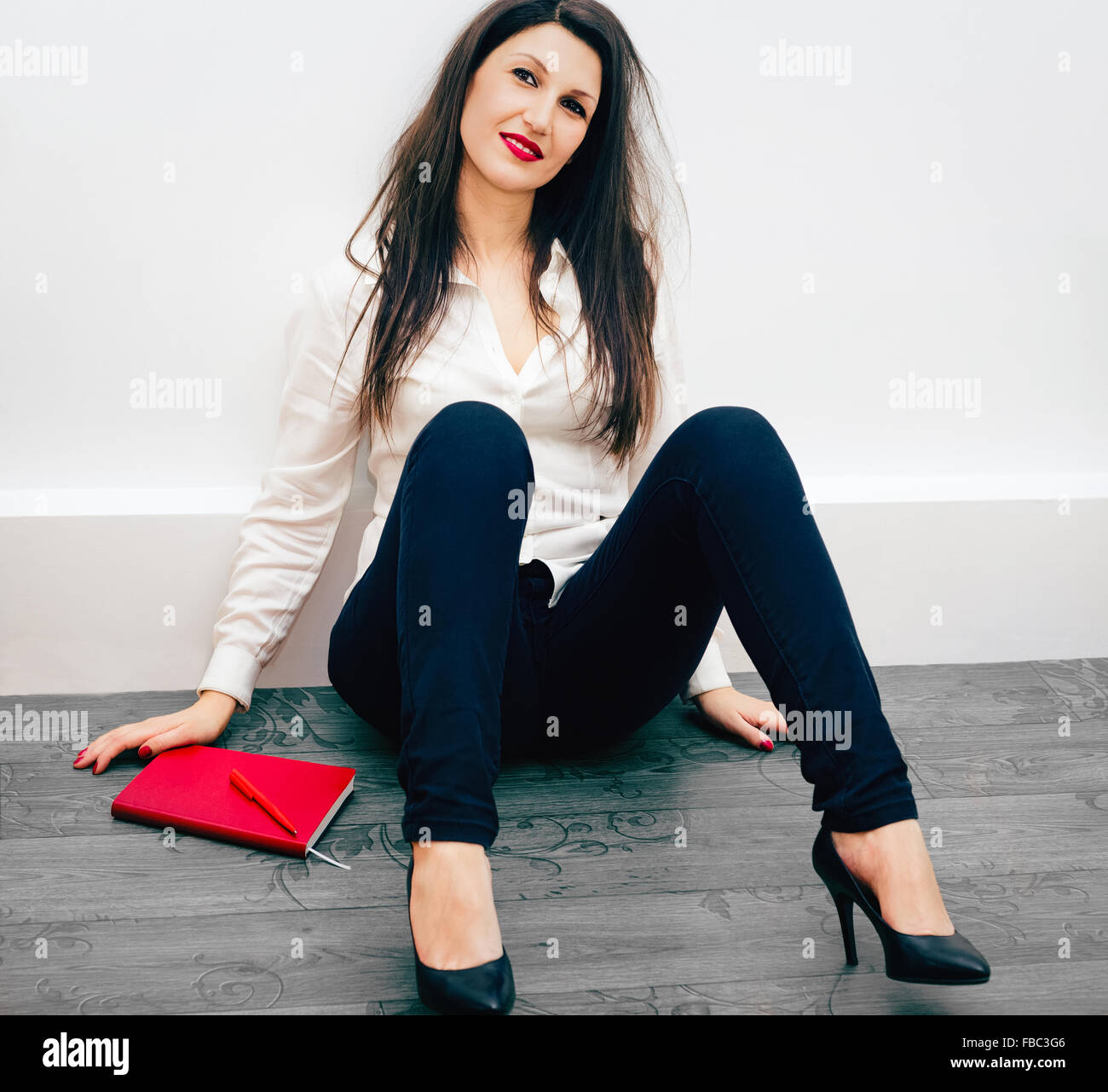 Beautiful woman sitting on the floor Stock Photo - Alamy